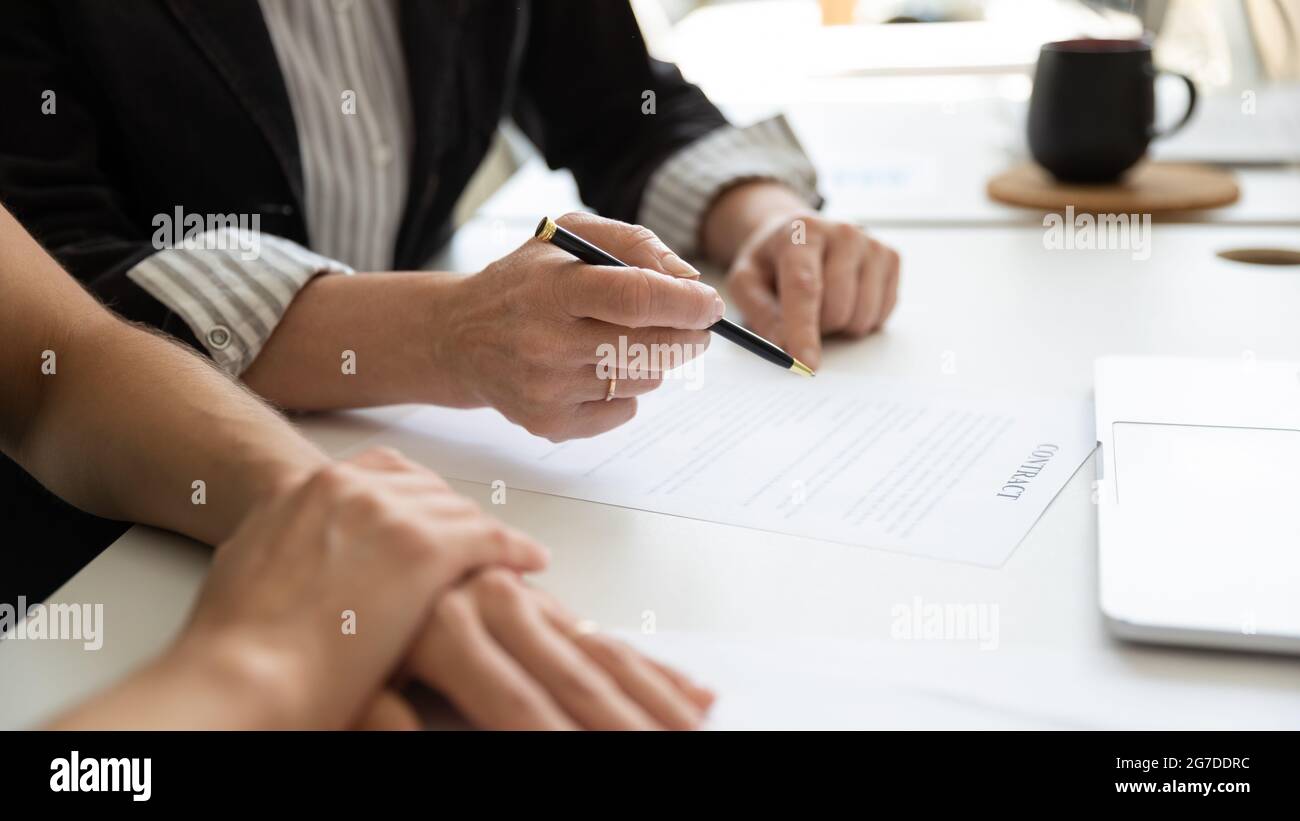 Hands of elderly female client reading and signing contract Stock Photo ...