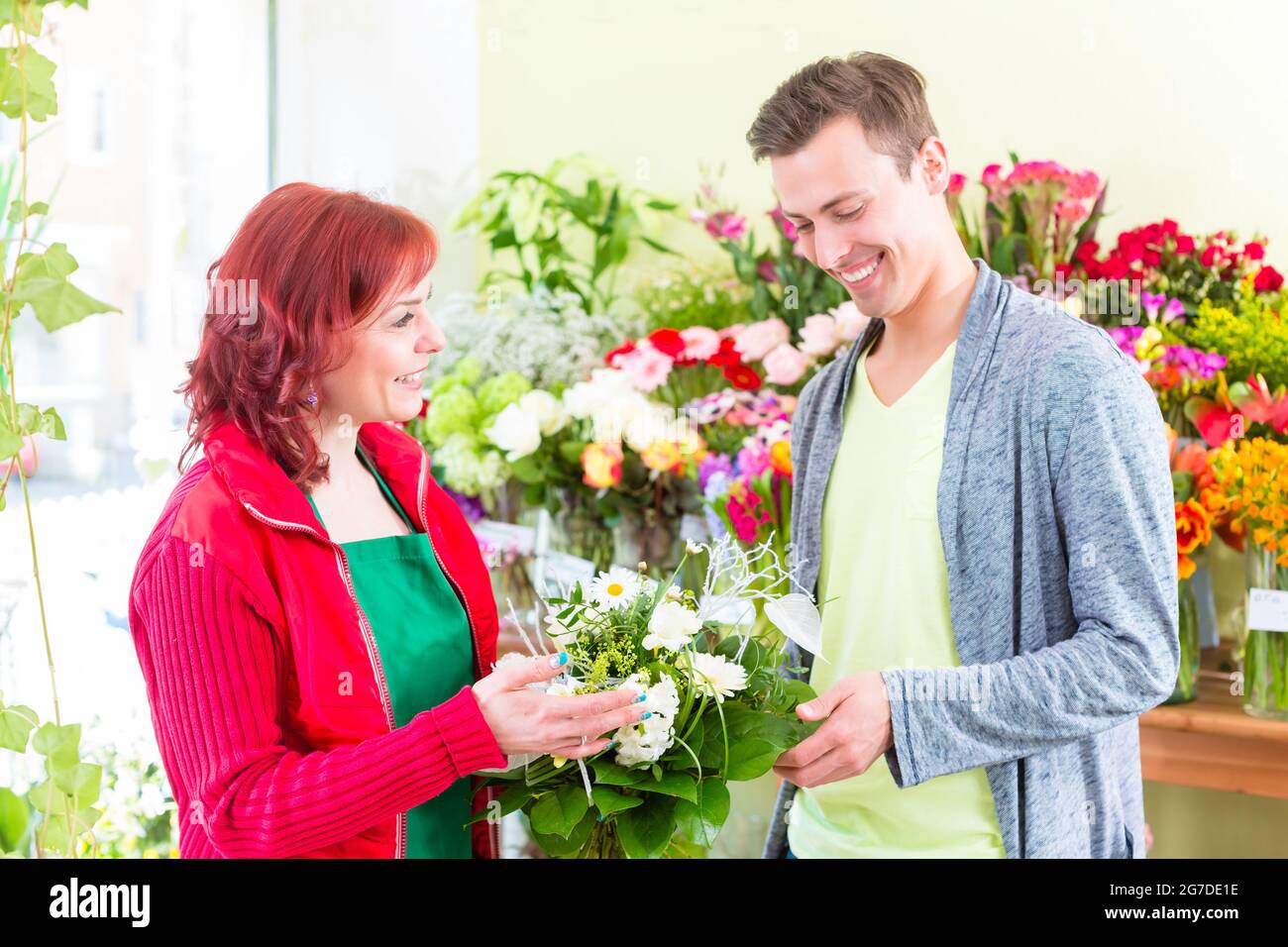 Female florist selling man flowers in flower shop Stock Photo - Alamy