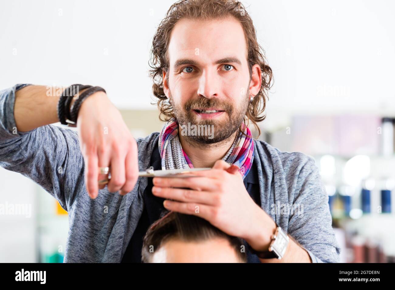 Barber trimming man hair in haircutter shop Stock Photo - Alamy