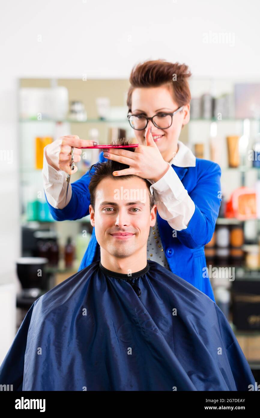 Female coiffeur cutting men hair in hairdresser shop Stock Photo - Alamy