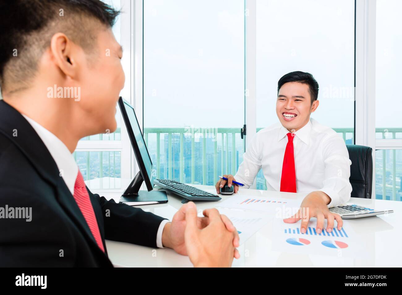 Asian banker offering client finance assets in bank office Stock Photo ...