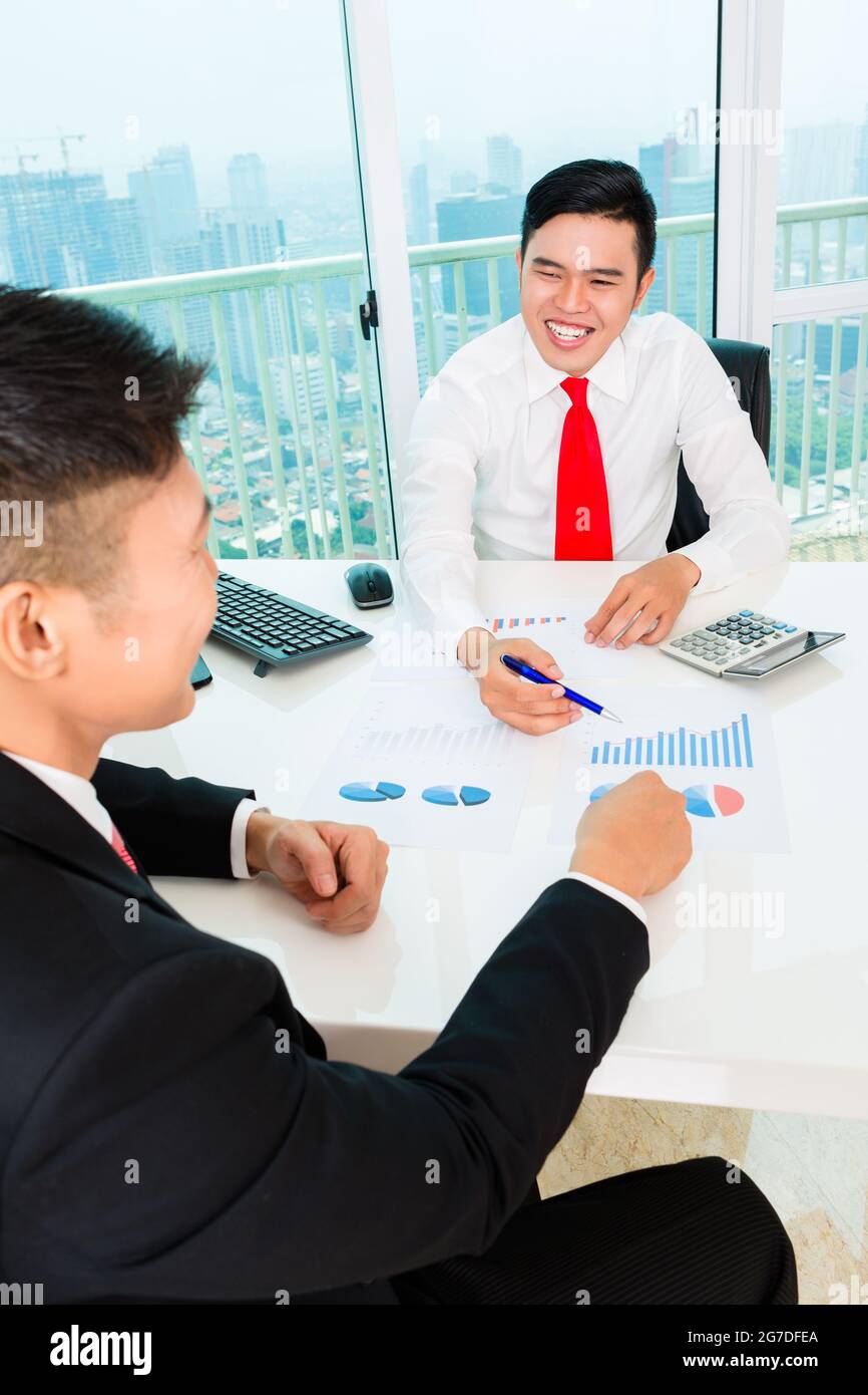 Asian banker offering client finance assets in bank office Stock Photo ...