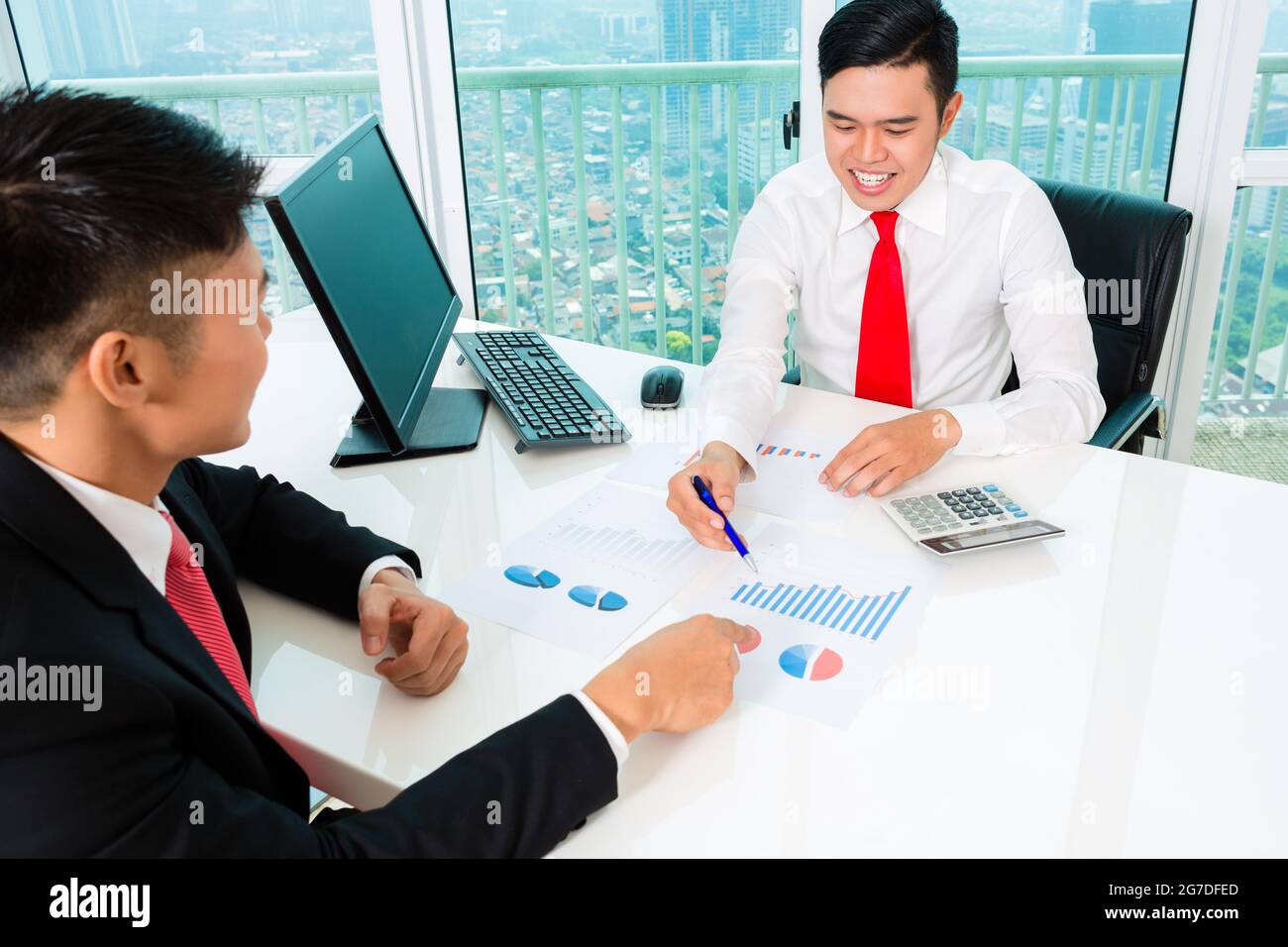 Asian banker offering client finance assets in bank office Stock Photo ...