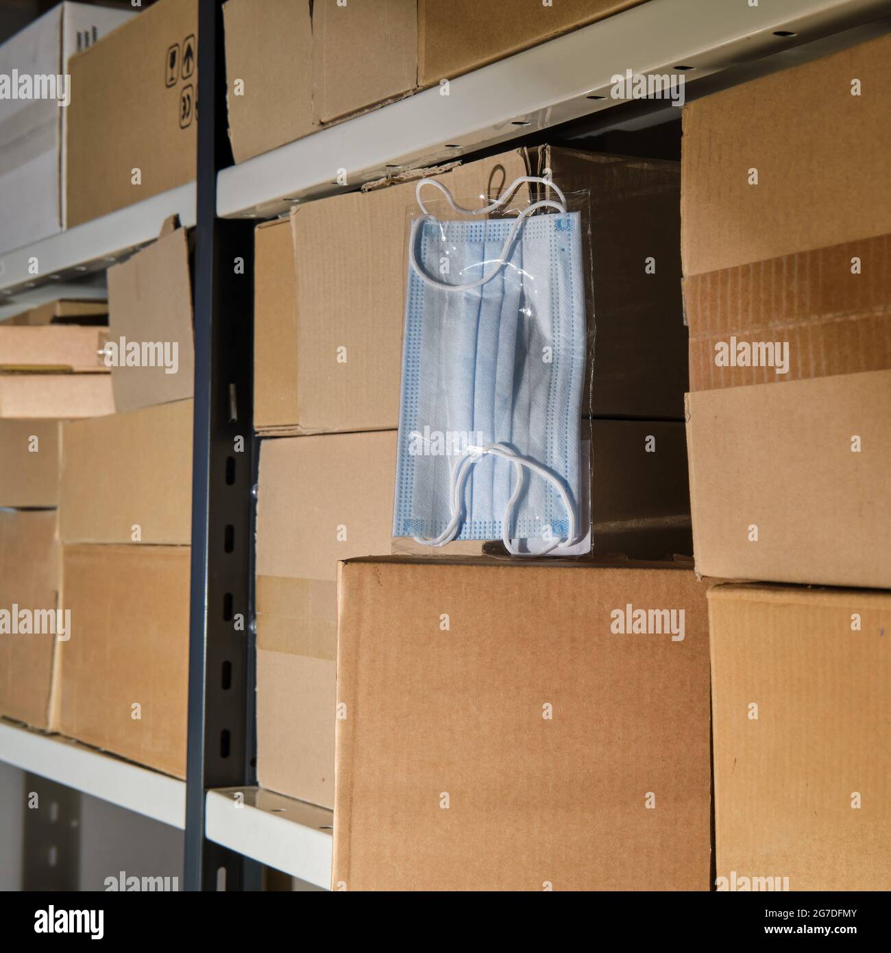 Storage of protective face masks in a warehouse among cardboard boxes ...