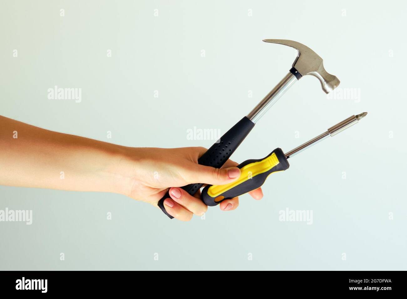Construction tools on outstretched arms. Hammer and screwdriver in hand ...