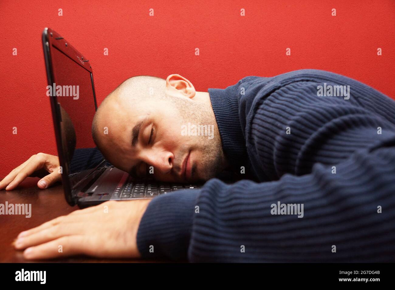 Tired man sleeping in front of his laptop while working Stock Photo - Alamy