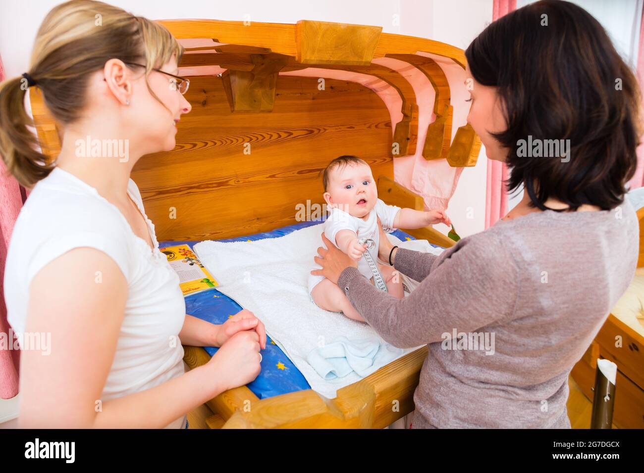Midwife examining newborn baby at postnatal care in practice Stock ...