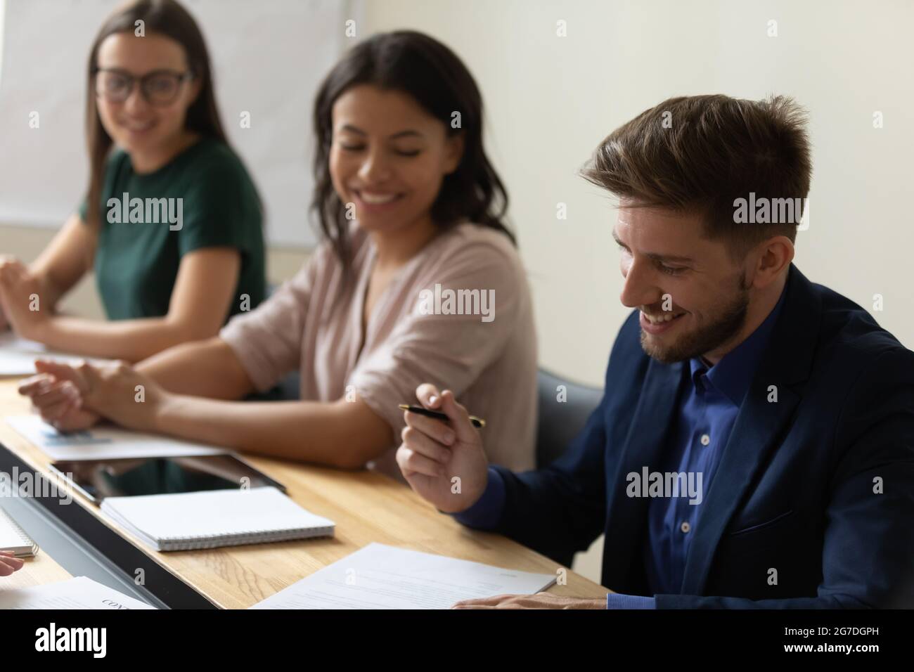 Happy confident businessman signing contract on meeting with partners ...