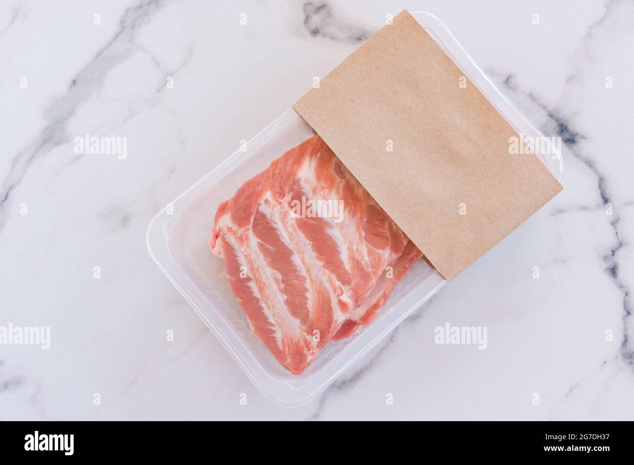 Raw pork ribs in vacuum packaging on marble background, logo mockup for ...