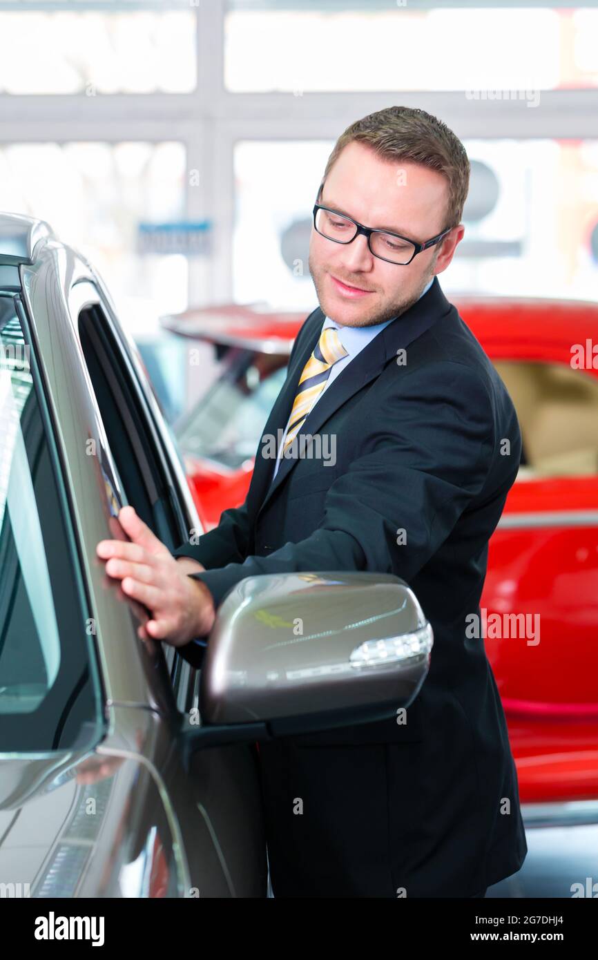 Salesman selling car at dealership Stock Photo - Alamy