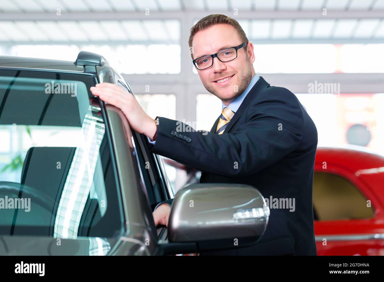 Salesman selling car at dealership Stock Photo - Alamy