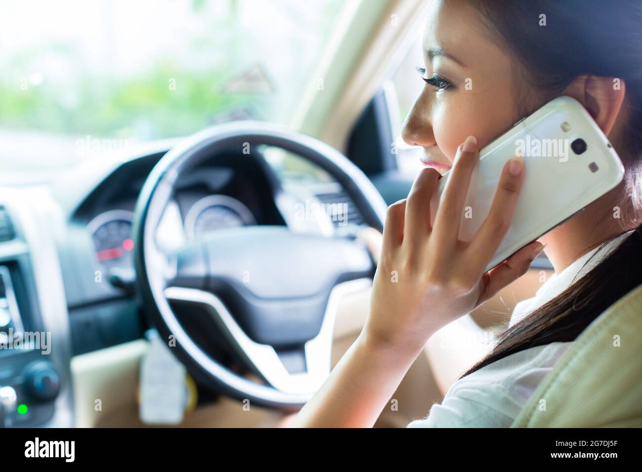 Asian Chinese young woman telephoning with mobile phone or smartphone ...
