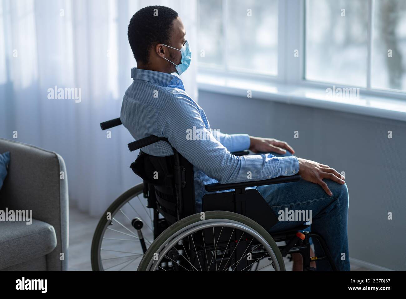 Impaired black guy in face mask suffering from depression at home ...
