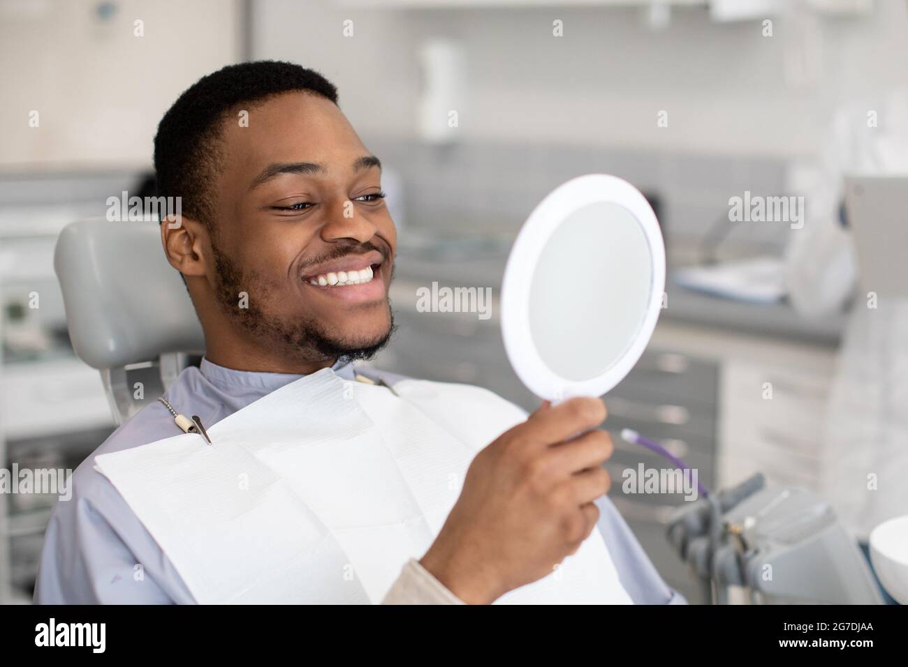 Portrait Of Happy Dental Clinic Patient Looking At Mirror After ...