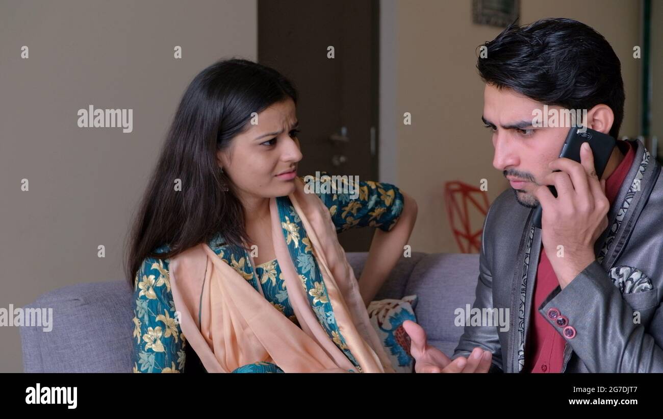Closeup of an Indian couple with the man talking on the phone and the ...