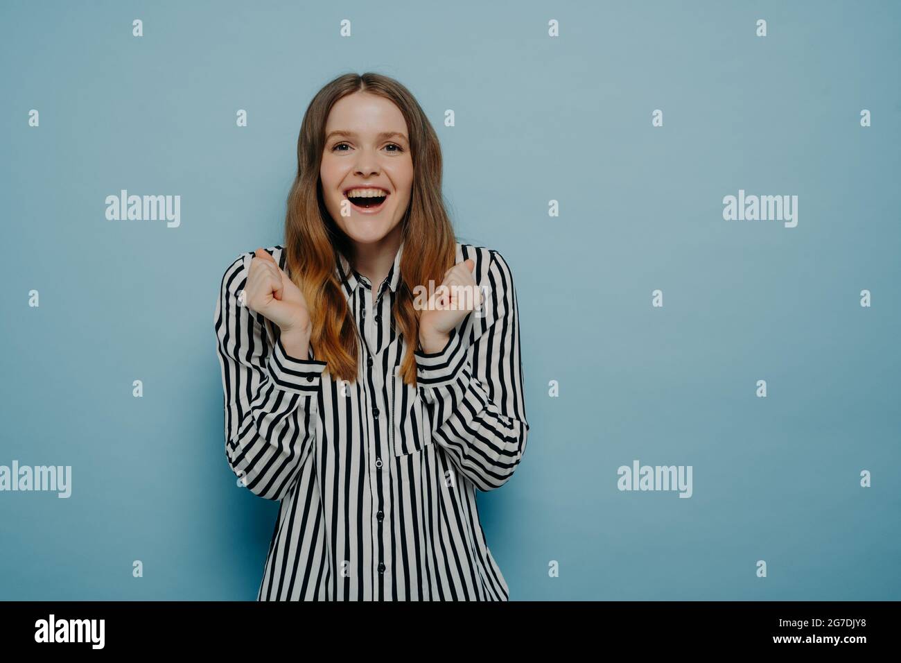 Smiling young woman being excited and celebrating success Stock Photo ...