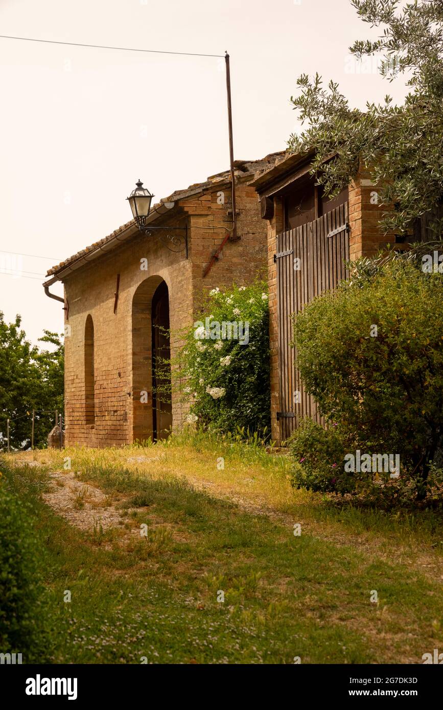 Beautiful red brick village house in Italy surrounded by plants and ...