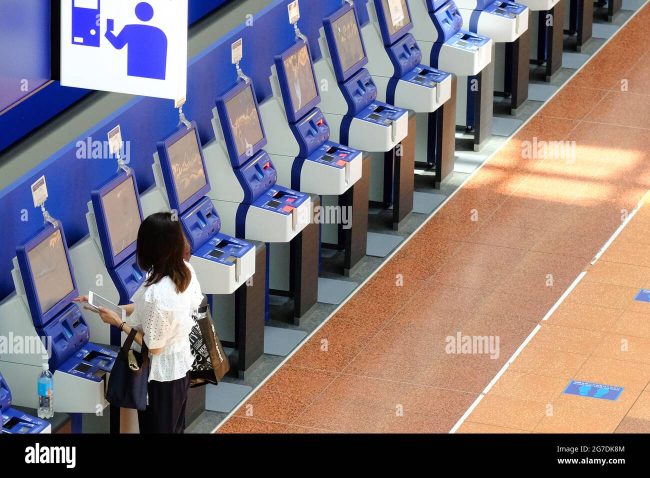 Tokyo, Japan. 24th June, 2021. A woman uses a self check-in kiosk at ...