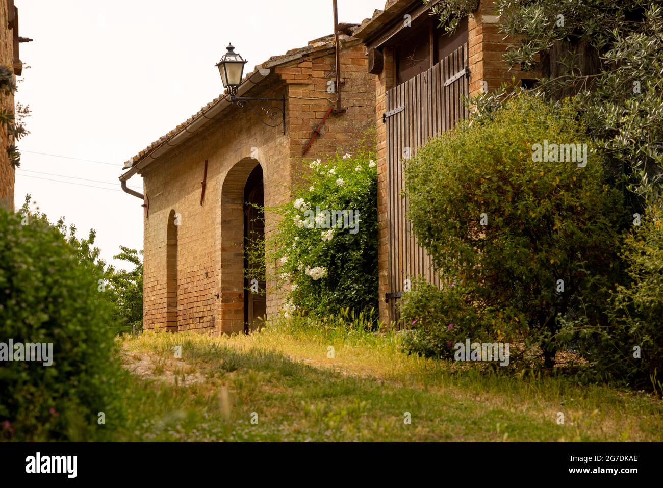 Beautiful red brick village house in Italy surrounded by plants and ...