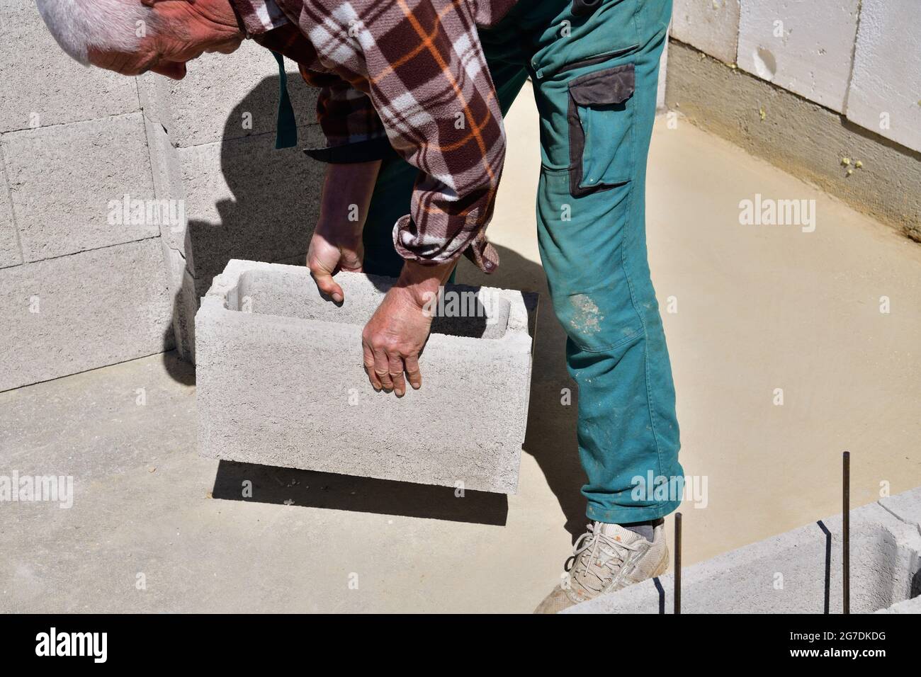 The mason places and prefabricated blocks into the wall at home on the ...