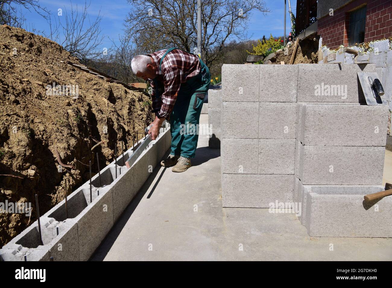 The mason places and prefabricated blocks into the wall at home on the construction site Stock ...