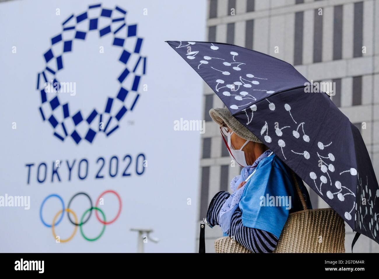 Tokyo, Japan. 25th June, 2021. A woman wearing a mask walks past a ...