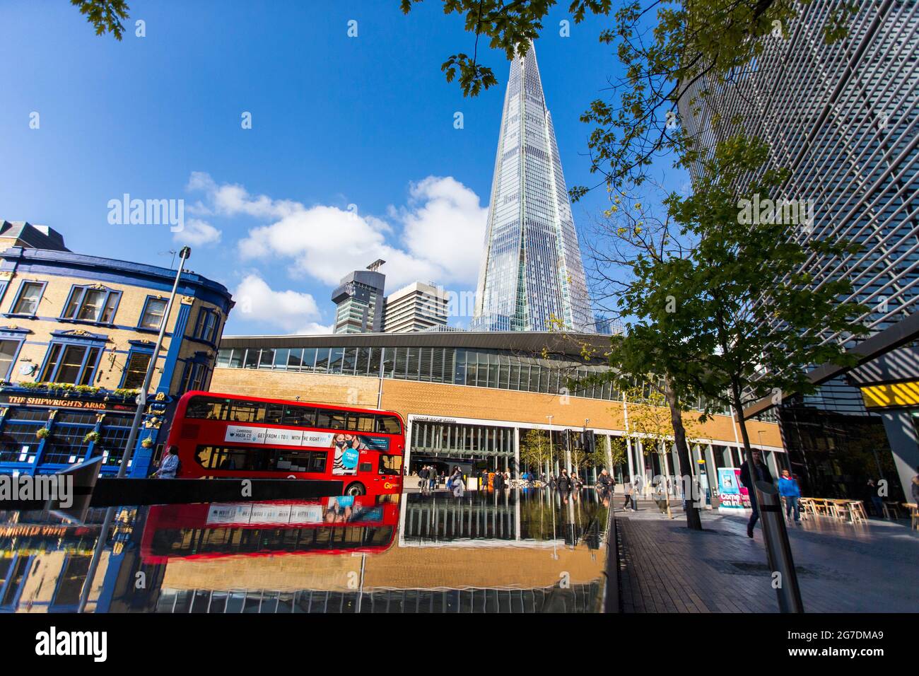 A London bus reflected in a water feature with the Shard behind, London ...