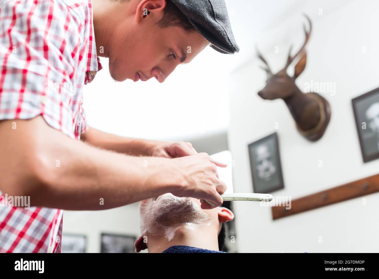 Close-up of hairdresser shaving with straight razor in salon Stock ...