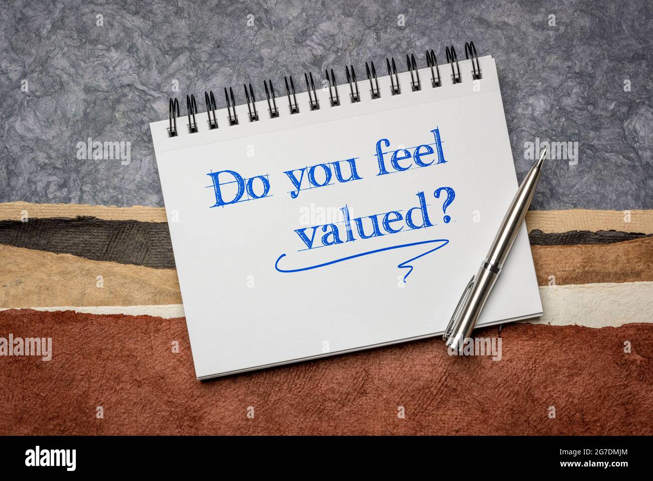 Do you feel valued? Handwriting in a notebook against abstract paper ...