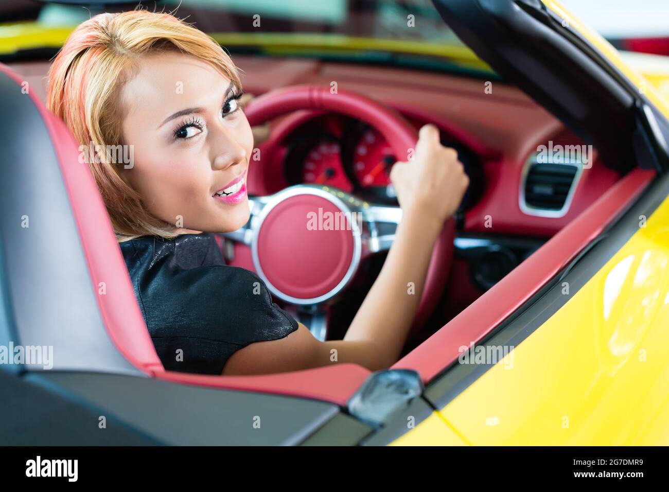 Asian woman testing new sports car Stock Photo - Alamy