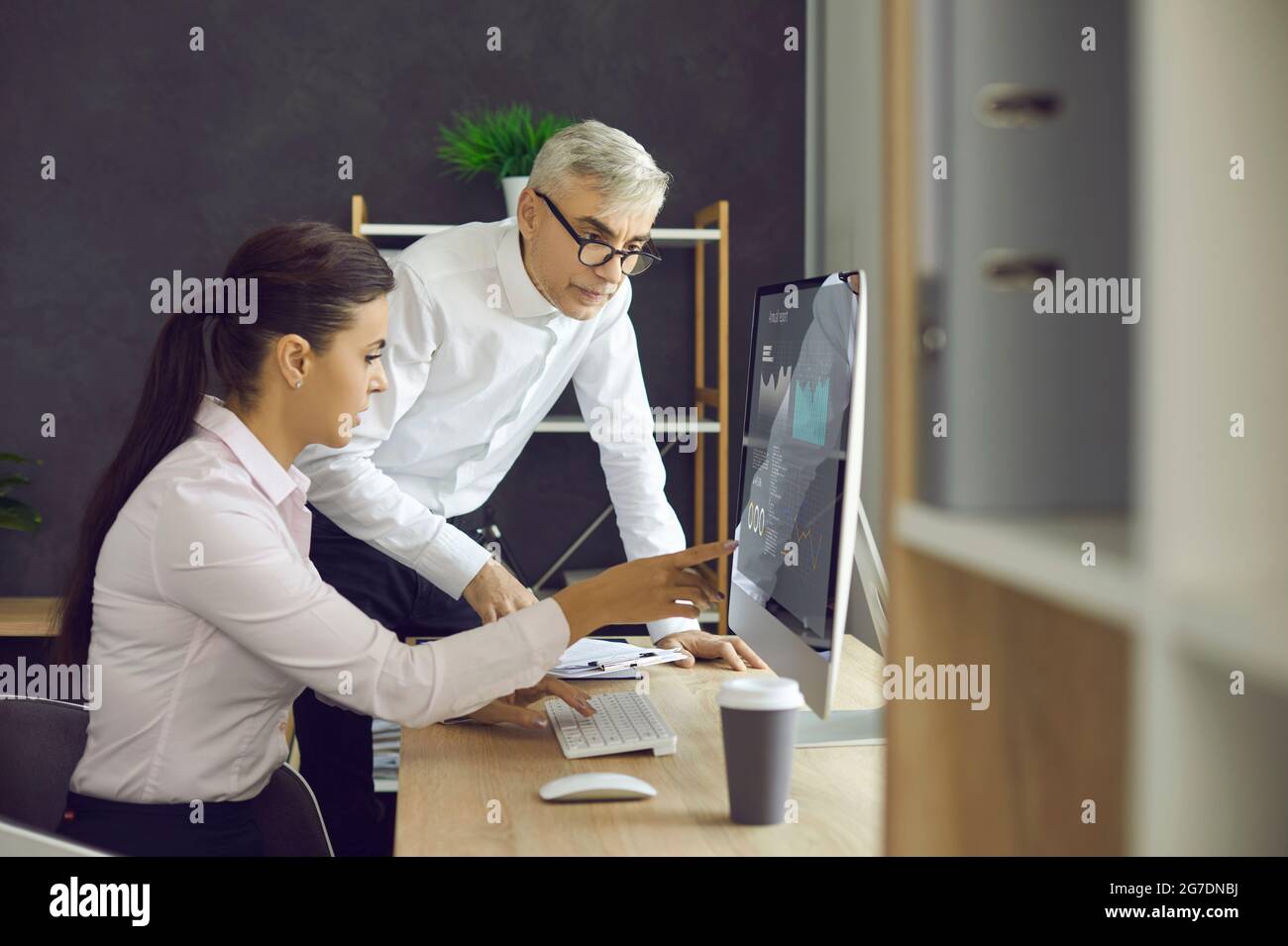 Two business colleagues looking at the screen of their office computer ...