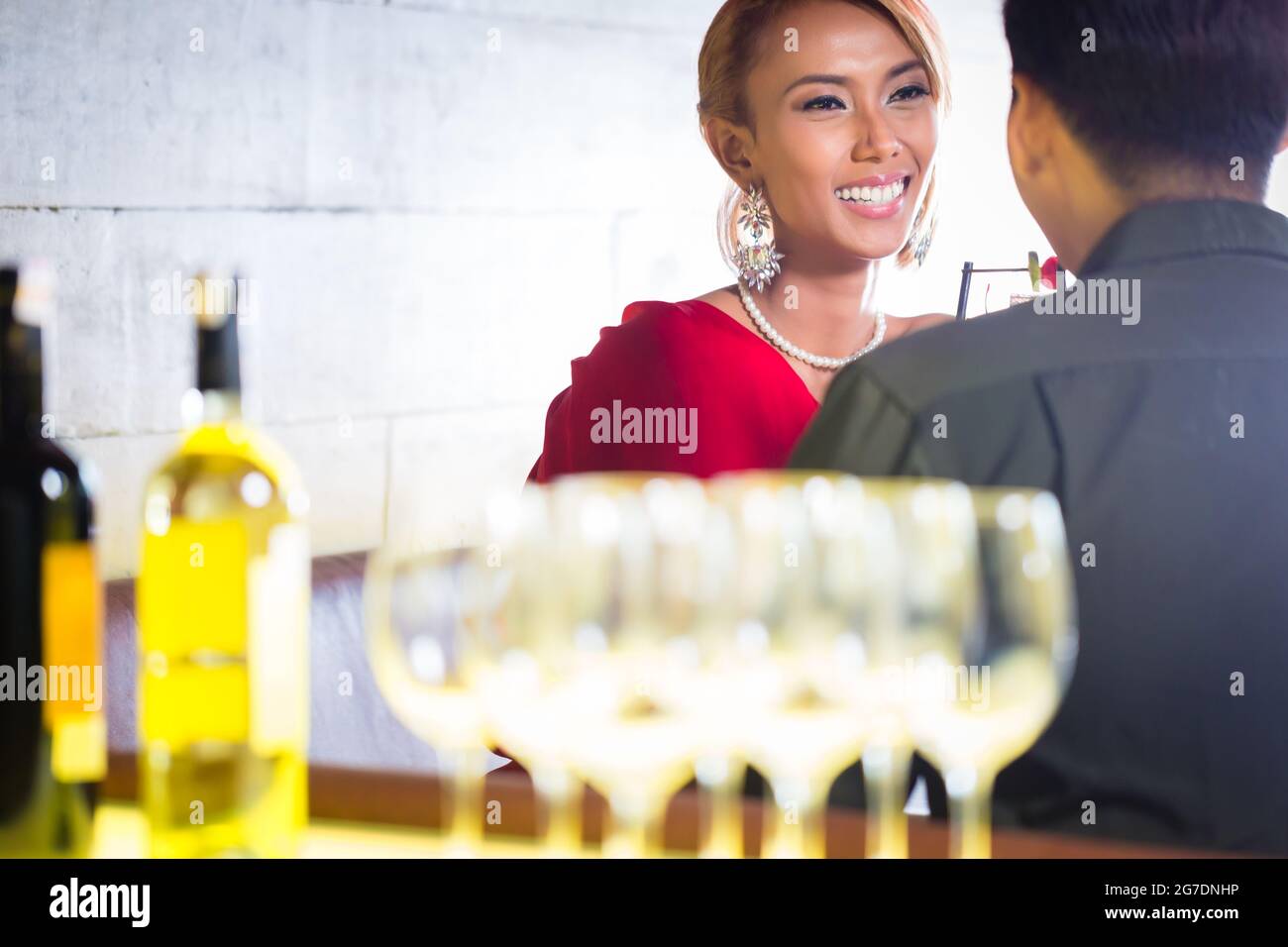Asian couple drinking white wine in fancy bar Stock Photo - Alamy