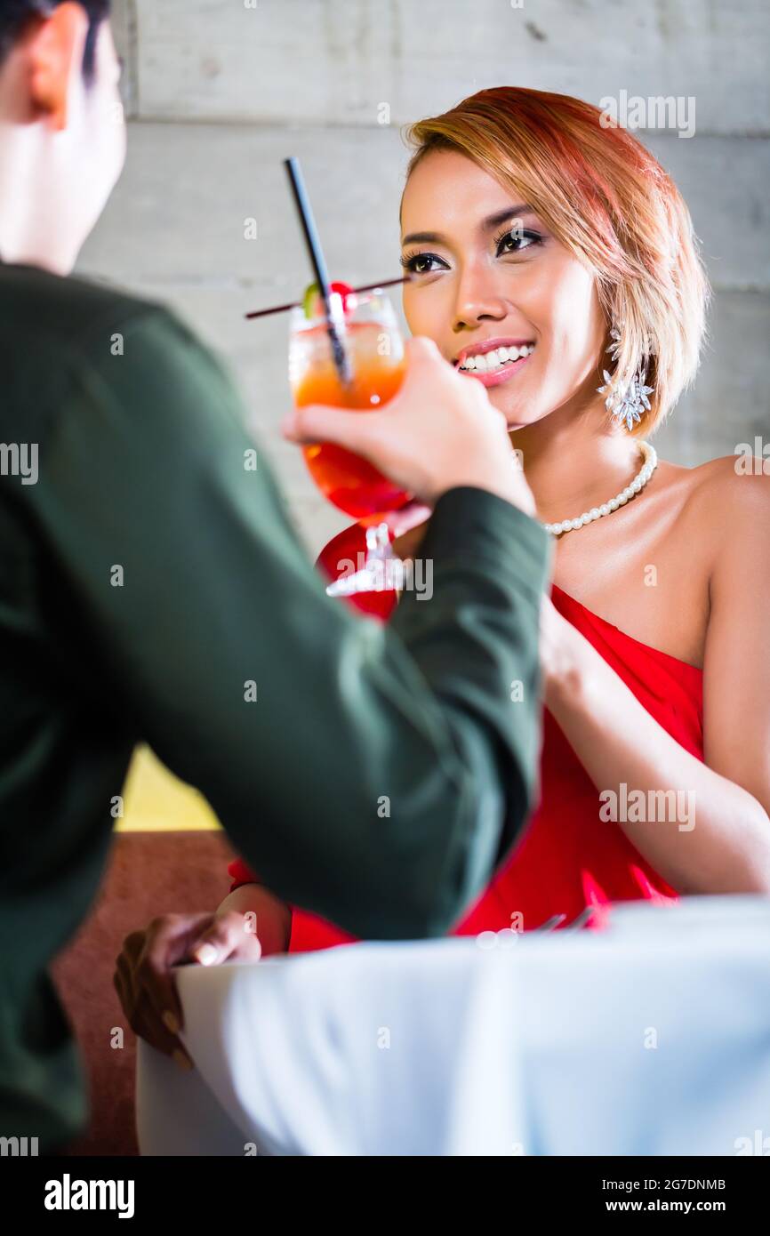 Asian couple drinking cocktails in fancy bar Stock Photo - Alamy