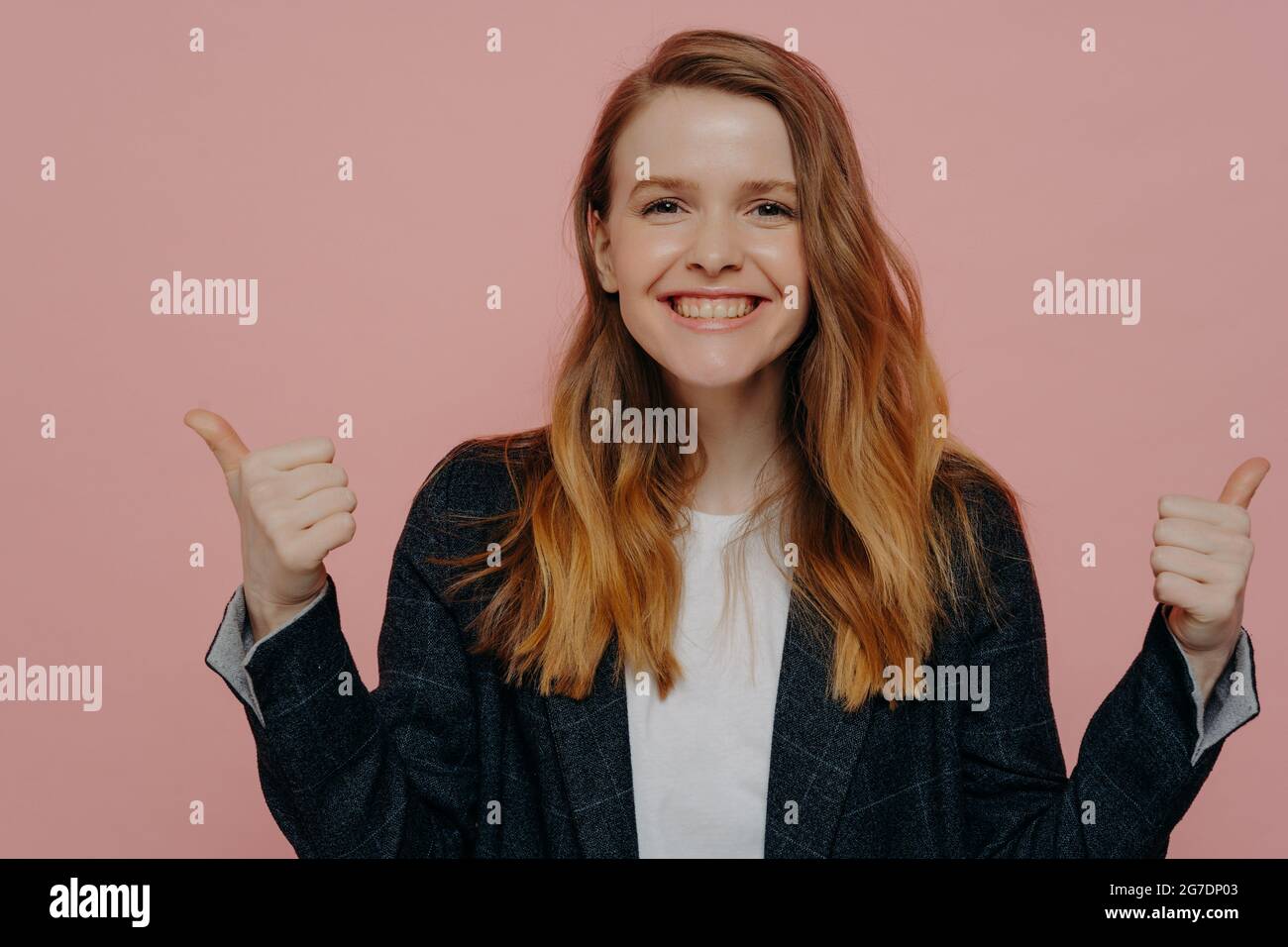 Happy ginger young girl in formal jacket showing thumbs up with both ...