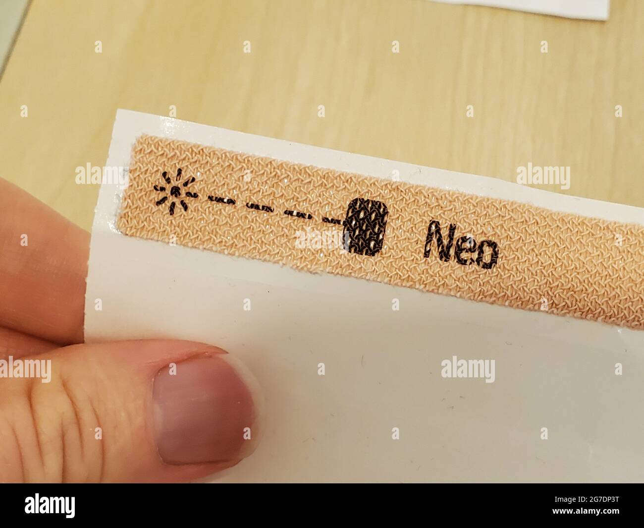 High-angle close-up of medical tape with a 'Neo' logo, attached to ...