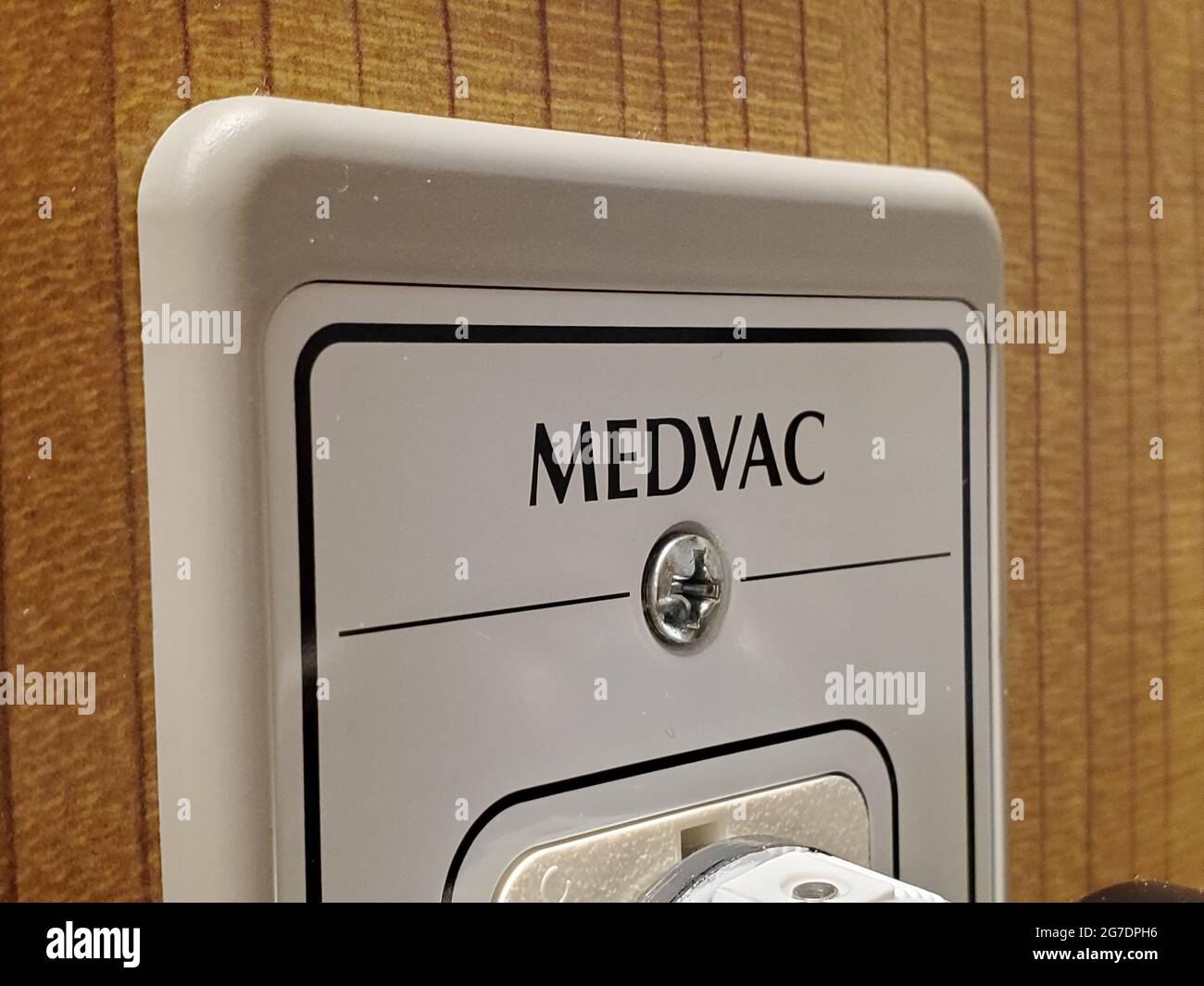 Angled close-up of a 'MEDVAC' label on a vacuum outlet attached to a ...