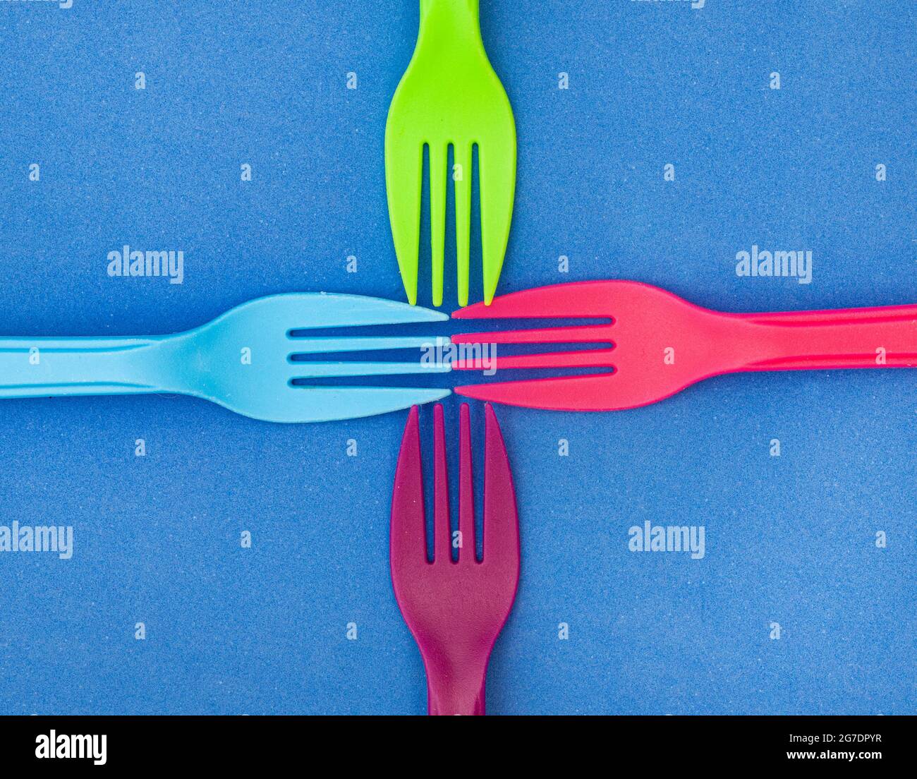 brightly colored plastic forks on colorful background with copy space ...