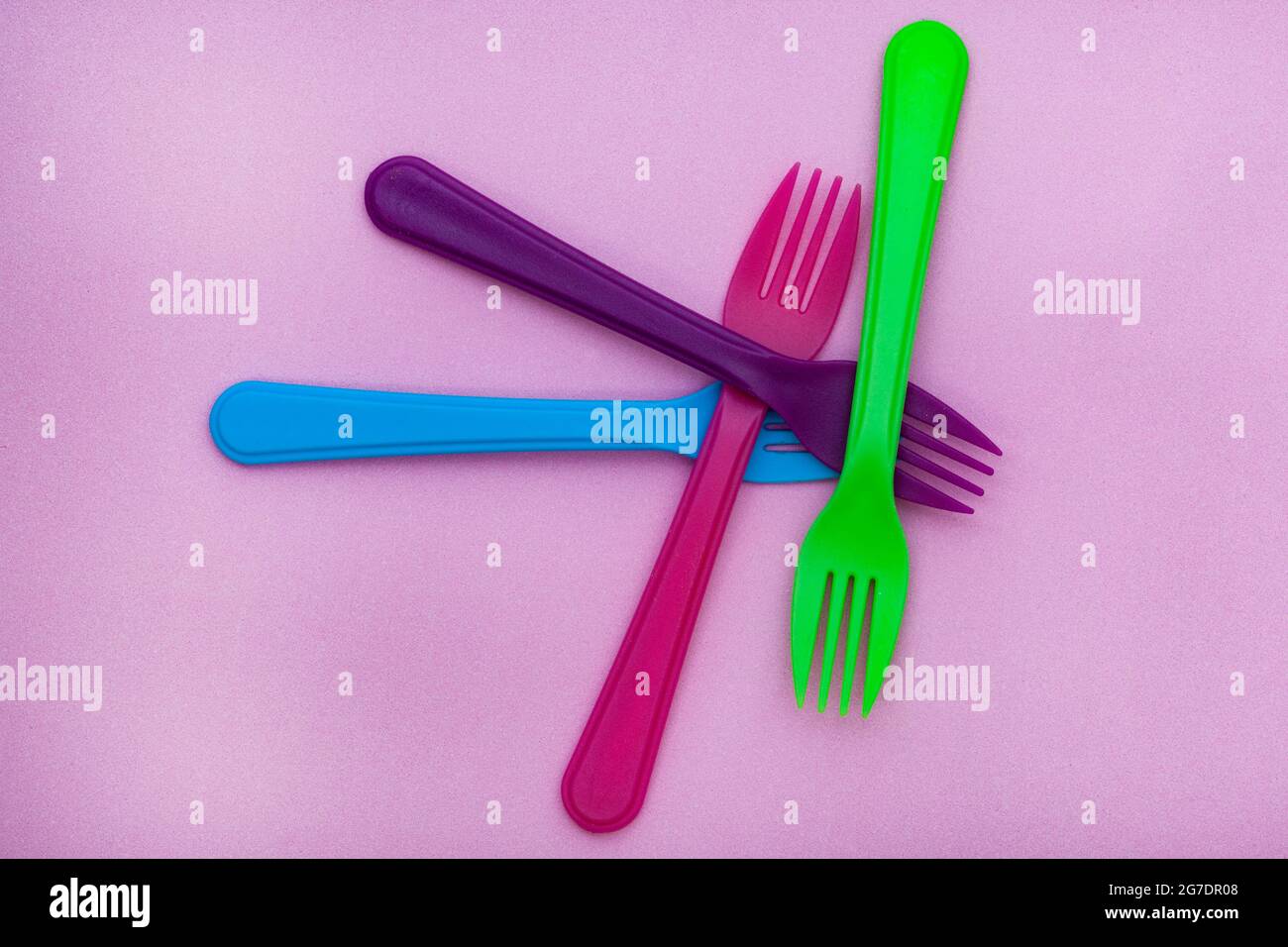 brightly colored plastic forks on colorful background with copy space ...