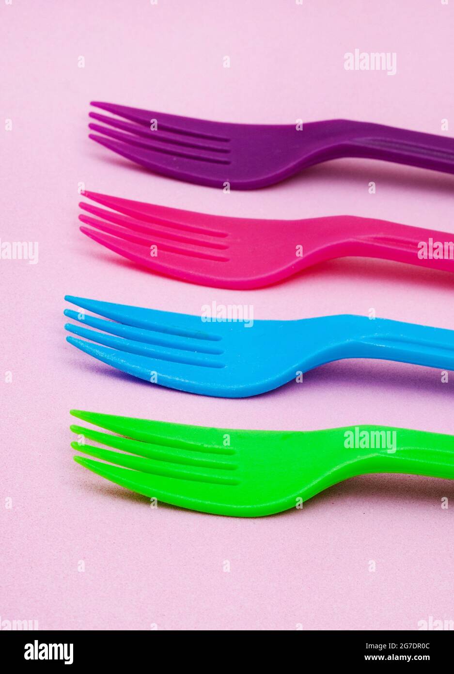 brightly colored plastic forks on colorful background with copy space ...