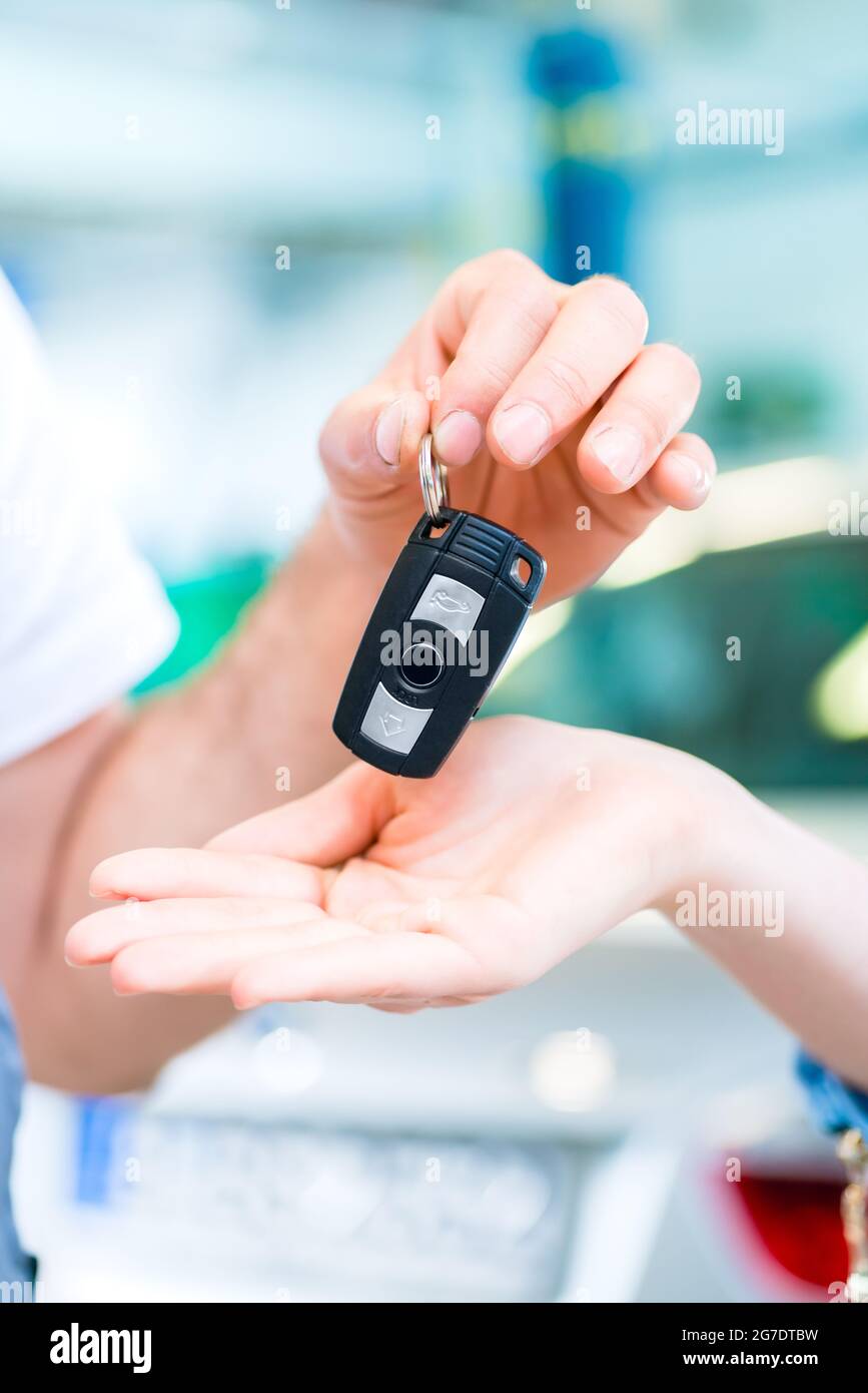 Workshop mechanic handing car to customer Stock Photo - Alamy