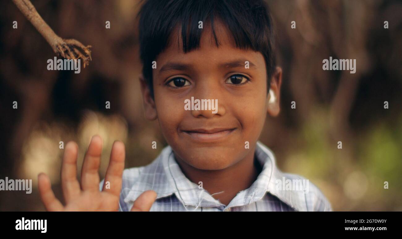 Closeup of a young Indian boy with cotton in one ear smiling at the ...