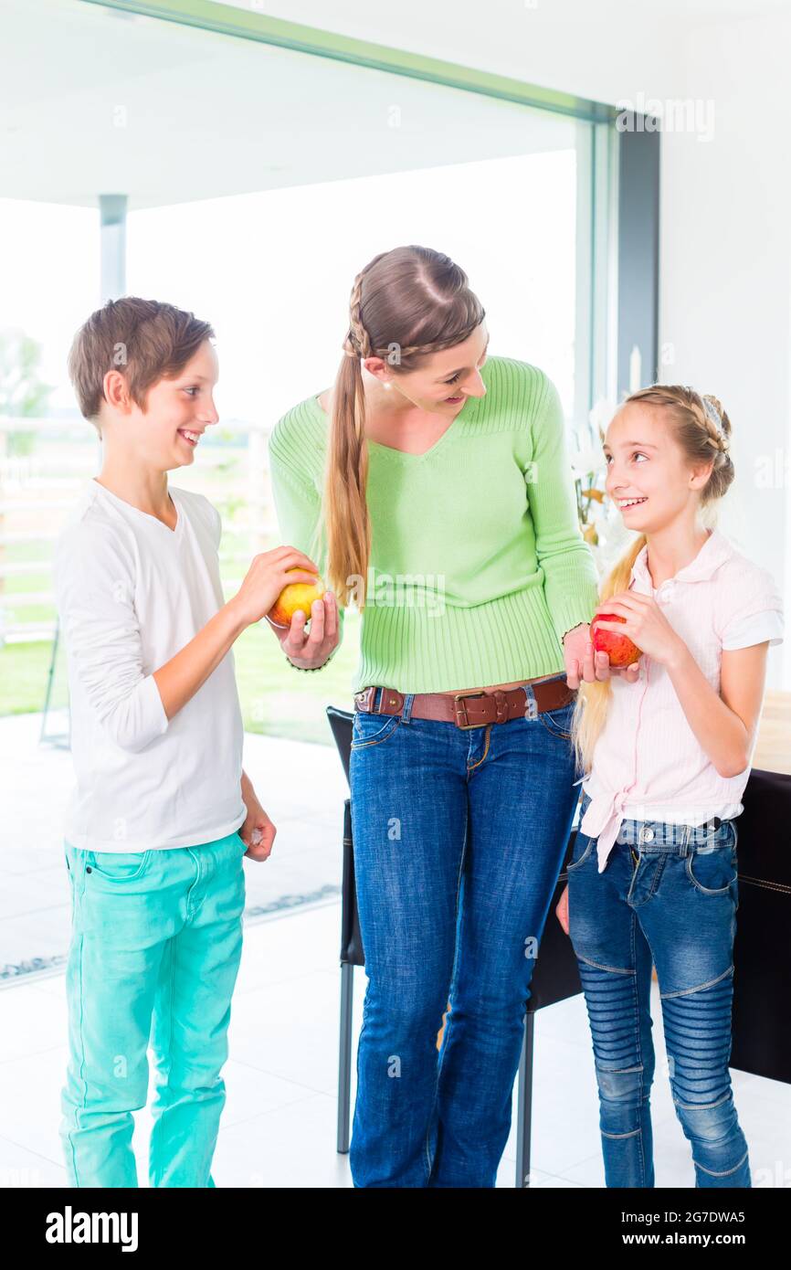 Mother giving children fresh fruits for healthy living Stock Photo - Alamy