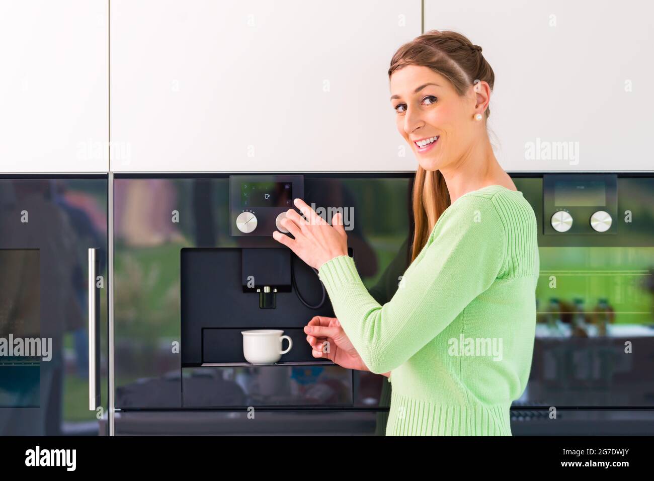 Woman using fully automatic coffee machine at home Stock Photo - Alamy