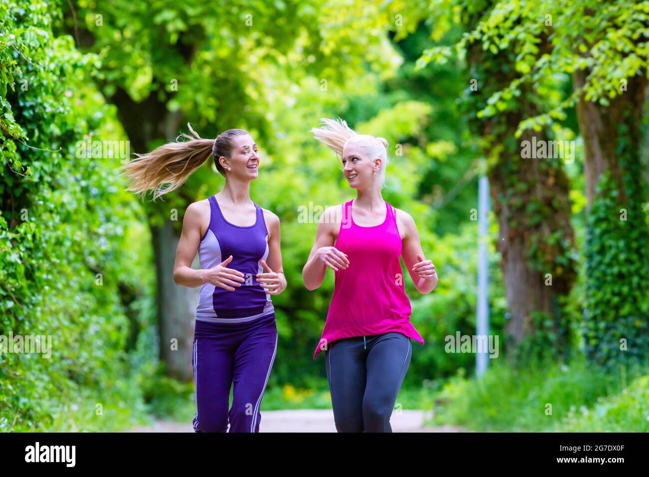Two women smile running hi-res stock photography and images - Alamy