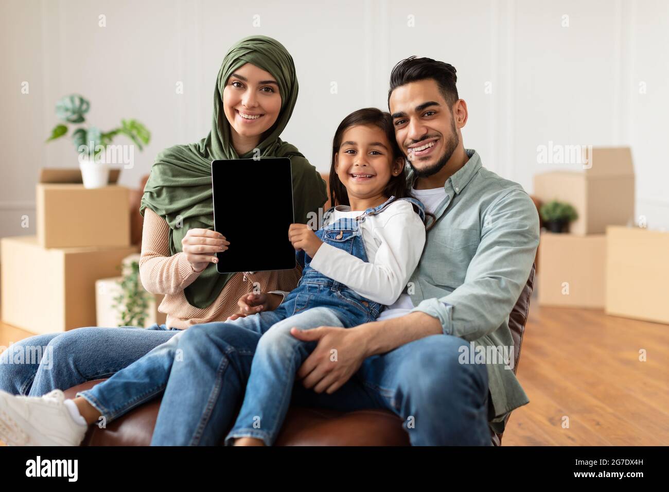Happy muslim family doing repair in new house using tablet Stock Photo ...
