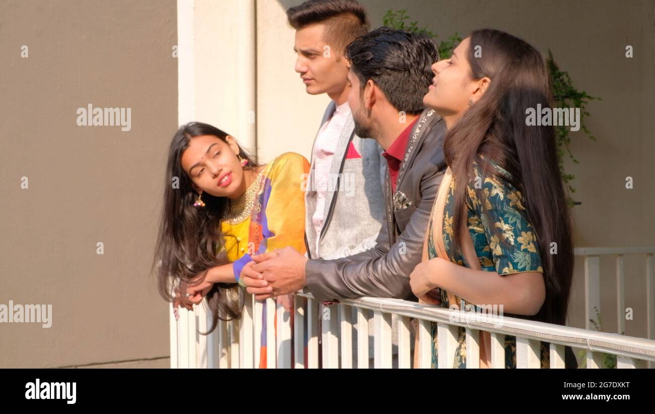 Shallow focus of Indian males and females talking to each other while ...