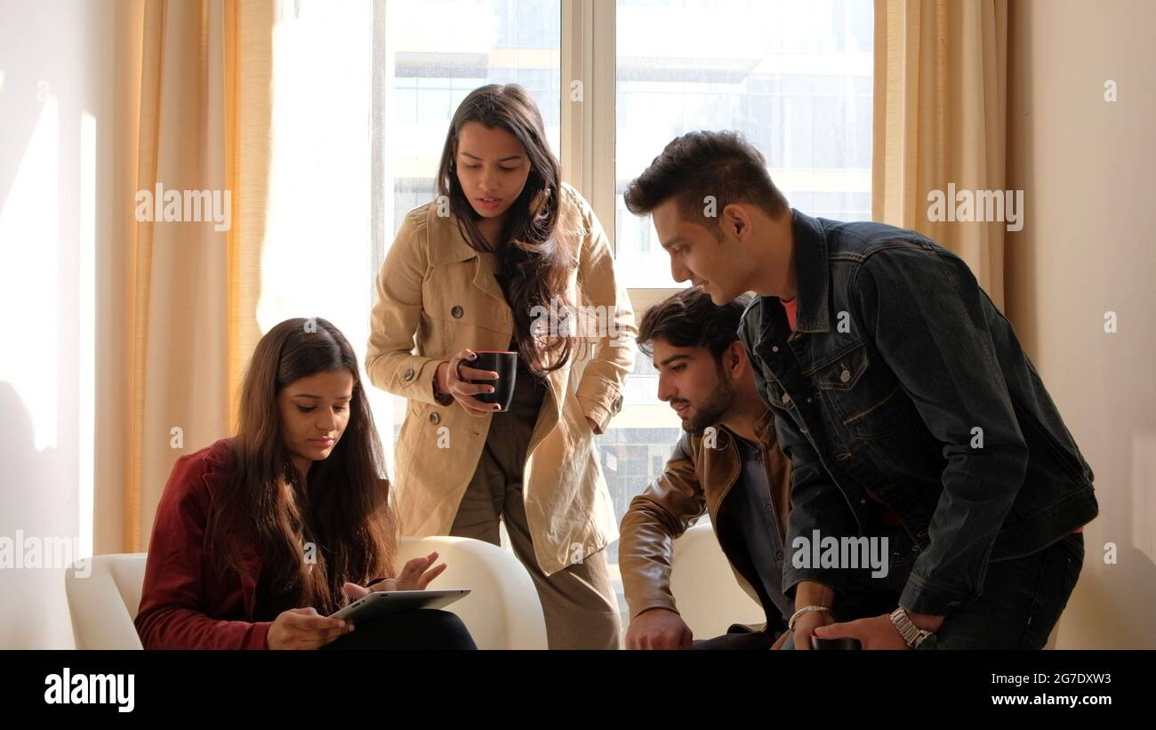 Group of Indian young men and women discussing something besides a ...