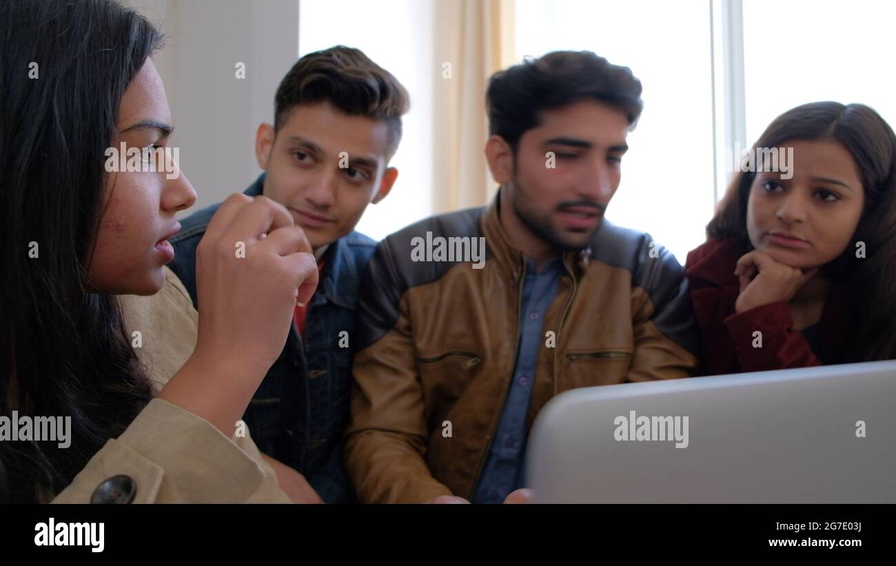 Group of Indian young men and women discussing something in front of a ...