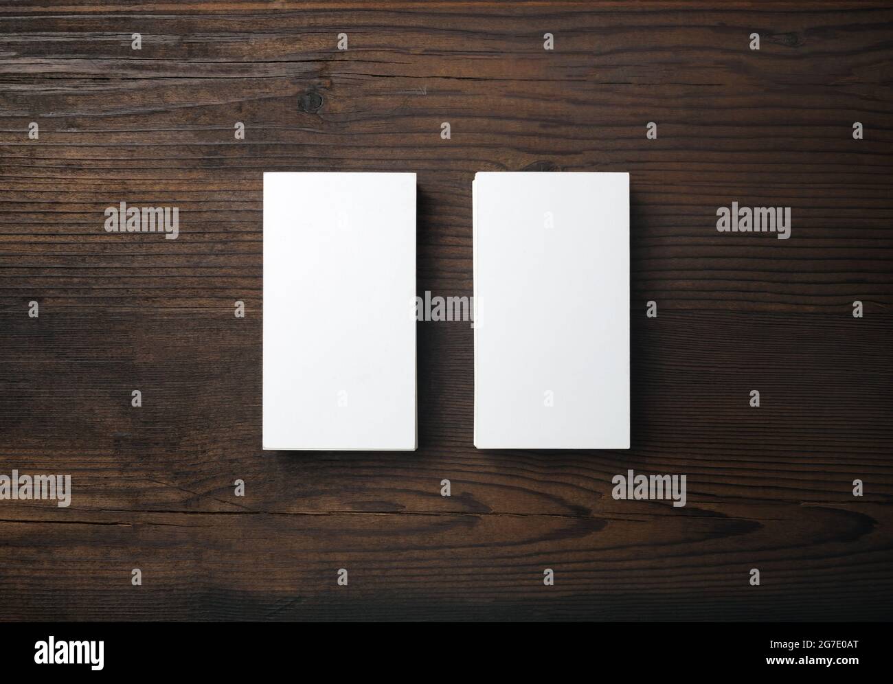 Photo of two blank business cards on wood table background. Branding ID ...