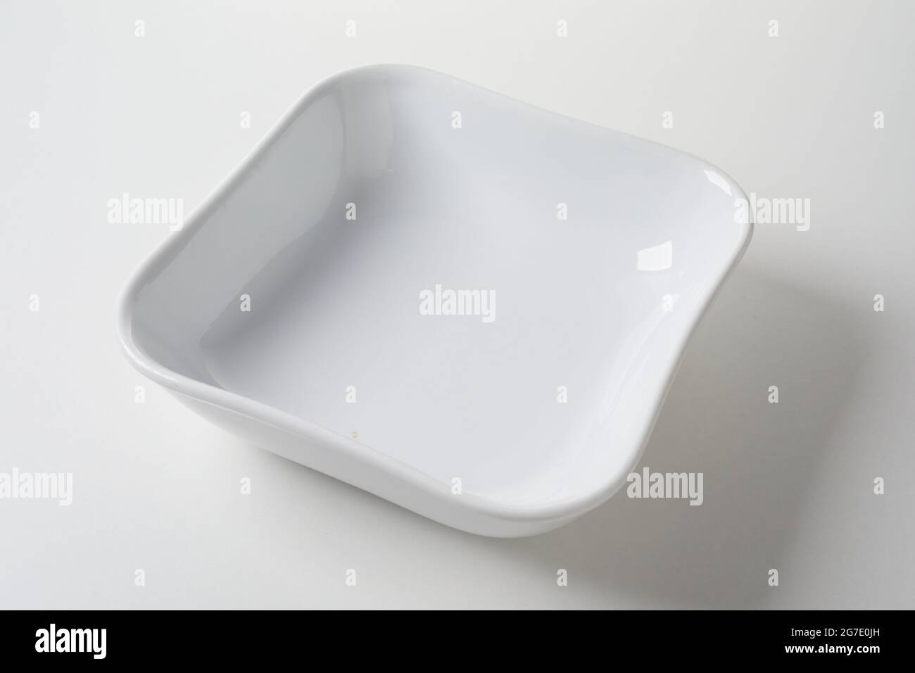 Plain simple empty clean white square ceramic dish on a white studio ...
